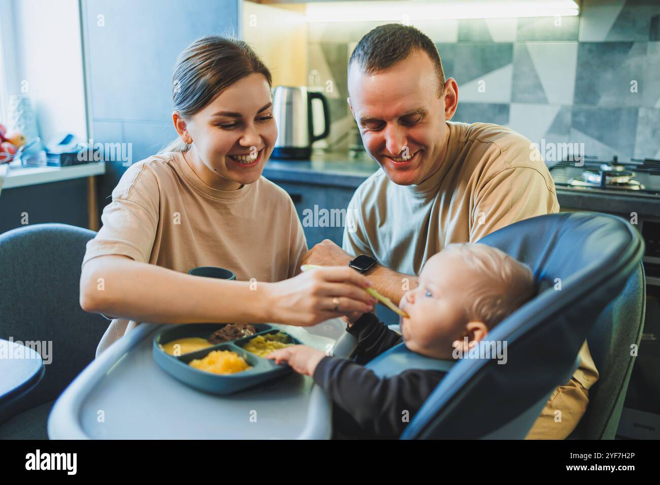 The first complementary food for a baby. A mother feeds puree to her 6 ...