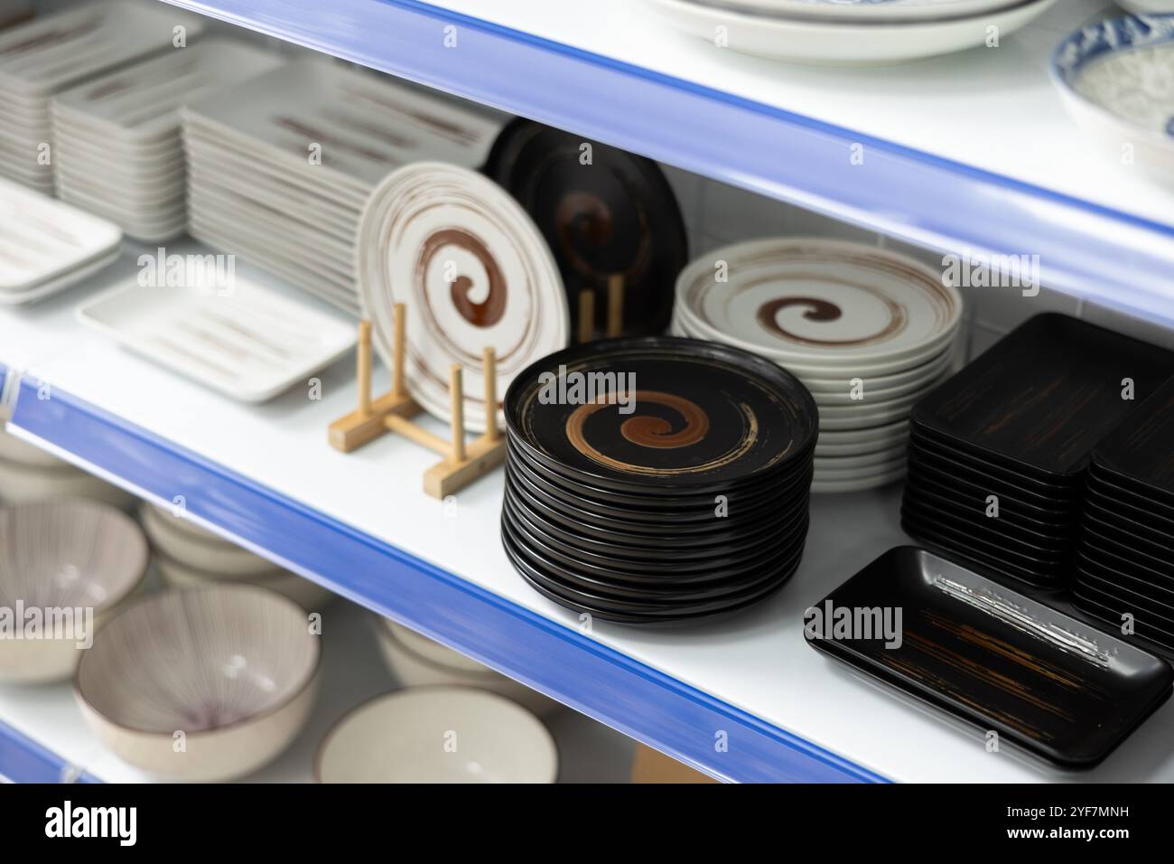 Various ceramic Asian dinnerware displayed on shelves in store Stock ...