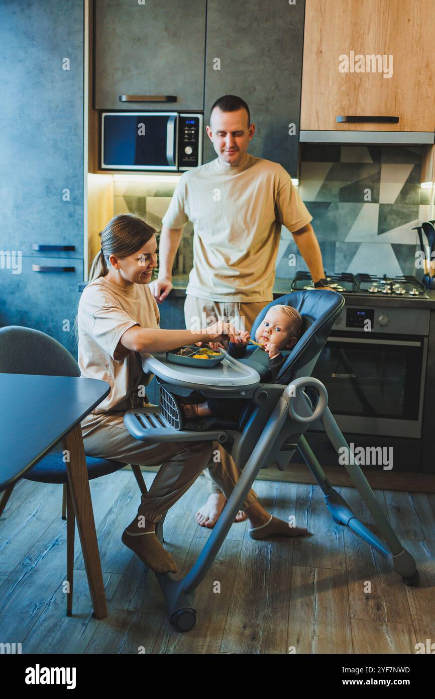 The first complementary food for a baby. A mother feeds puree to her 6 ...