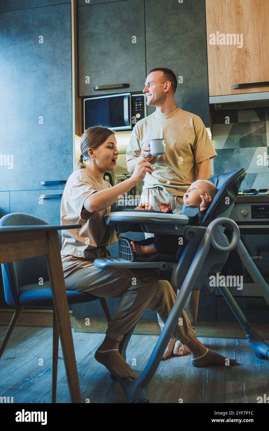 The first complementary food for a baby. A mother feeds puree to her 6 ...