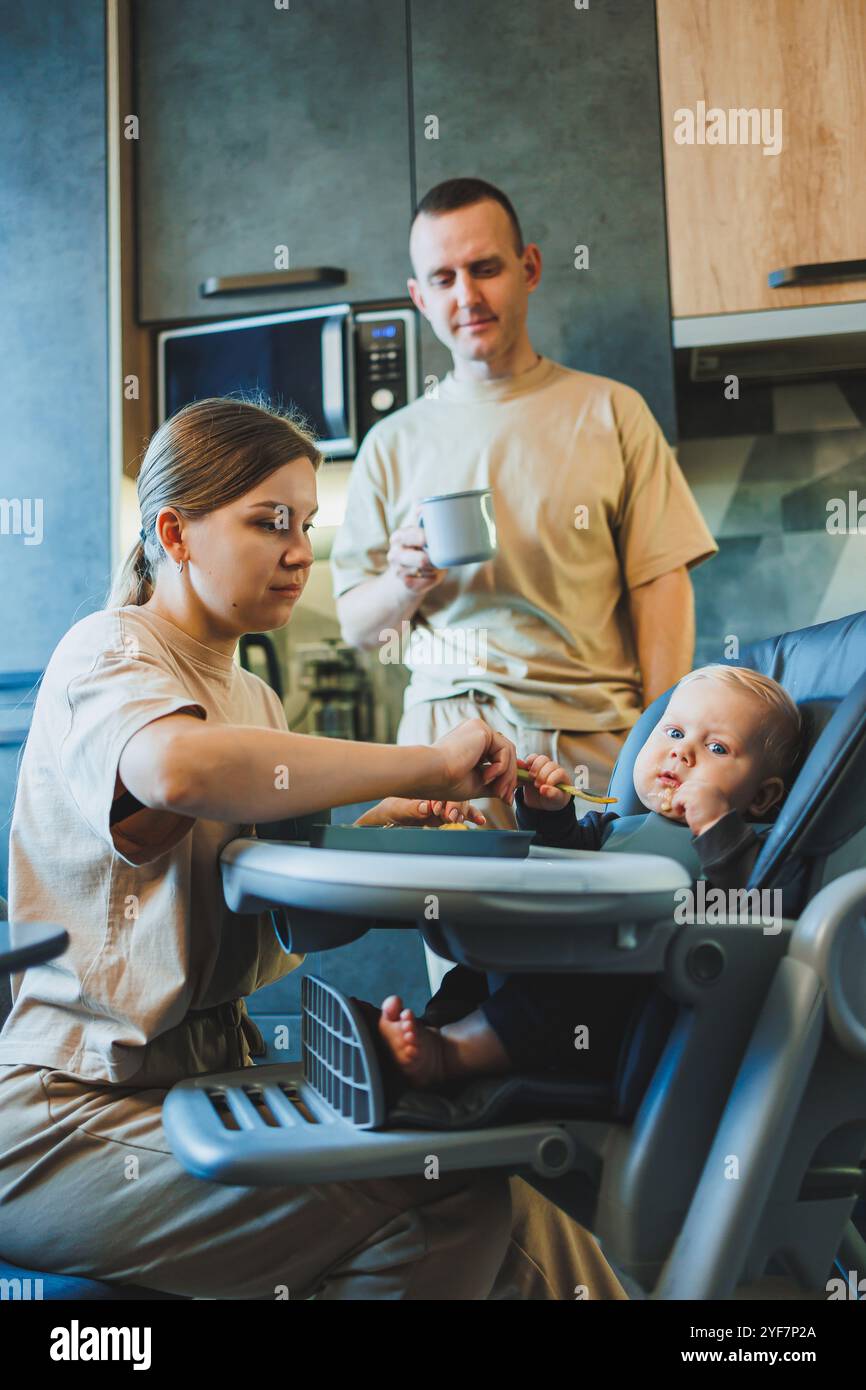 The first complementary food for a baby. A mother feeds puree to her 6 ...