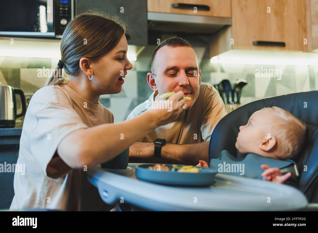 The first complementary food for a baby. A mother feeds puree to her 6 ...