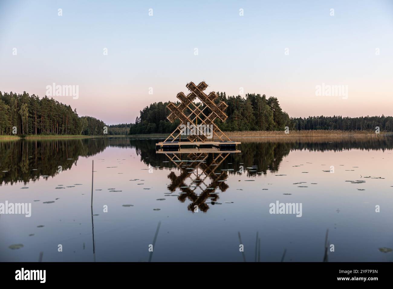 A tranquil lake features a floating wooden structure with interlocking ...