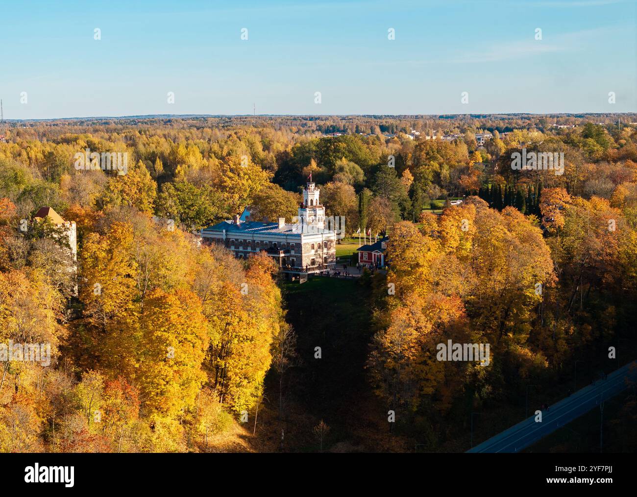 A castle in Sigulda, Latvia, is surrounded by vibrant autumn foliage ...