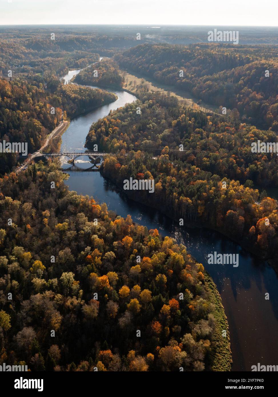 The Gauja River winds through autumn forests in Sigulda, Latvia, with a ...
