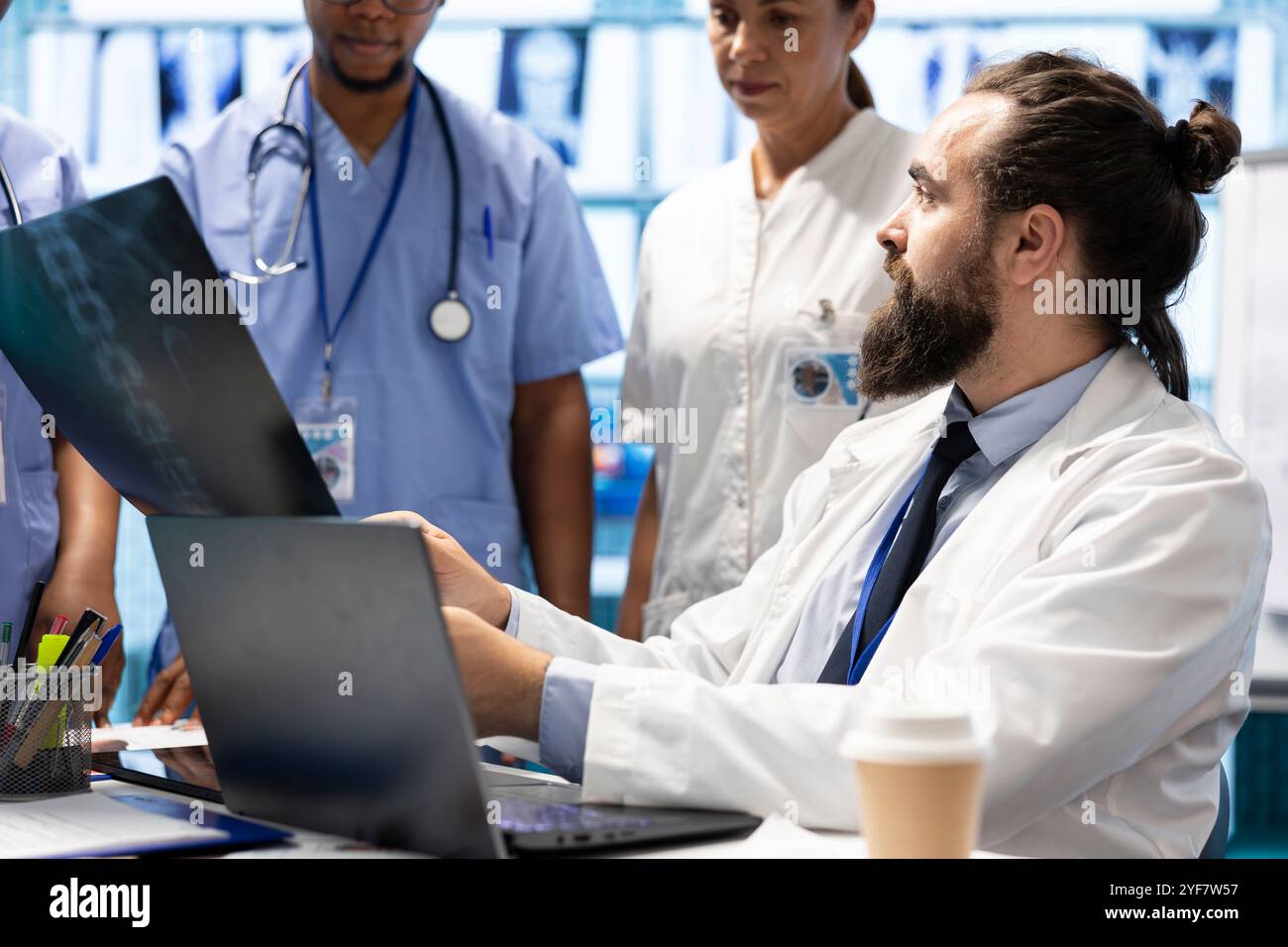 Diverse team of healthcare providers reviewing test lab results in a ...