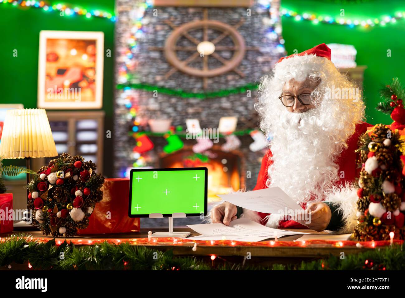 Father Christmas reads letters with wishes next to green screen on ...
