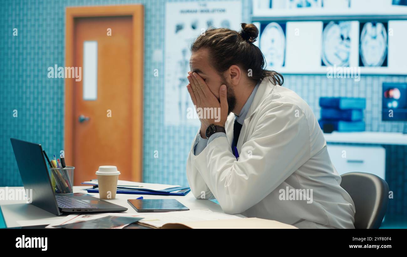 Tired worried doctor working after hours to find the diagnostic for a ...