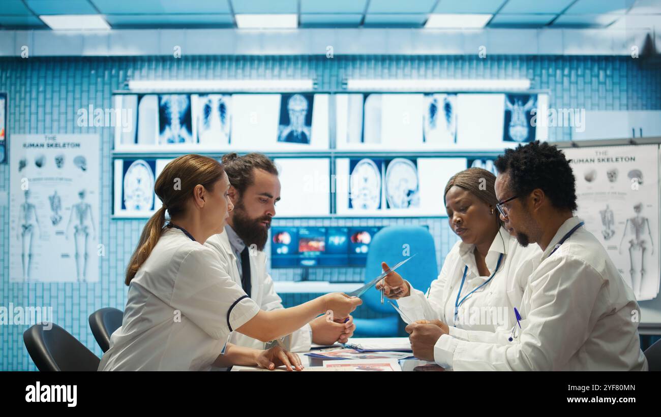 Radiologists and doctors analyze x rays and discuss patient care in a ...