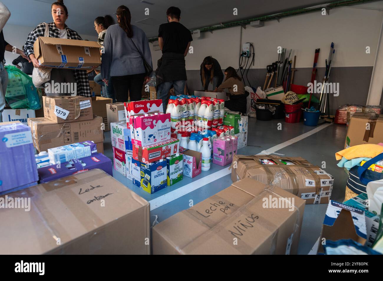 Volunteers organizing citizen donations of milk at a collection point ...