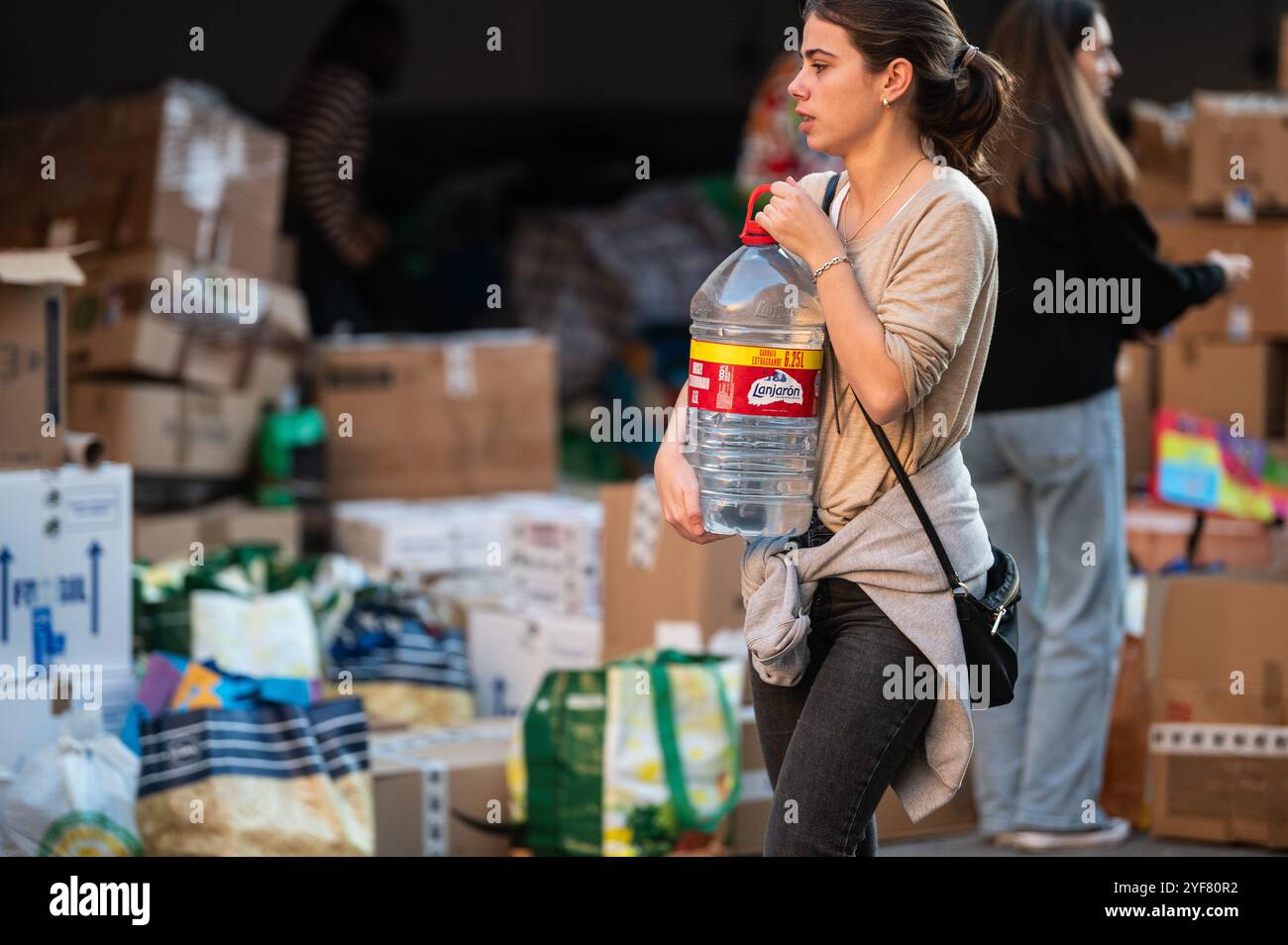 A volunteer organizing citizen donations of water at a collection point ...