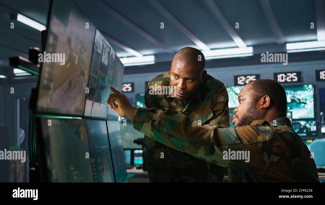 Team Of Soldiers Looking At Screens In Command Center Housing