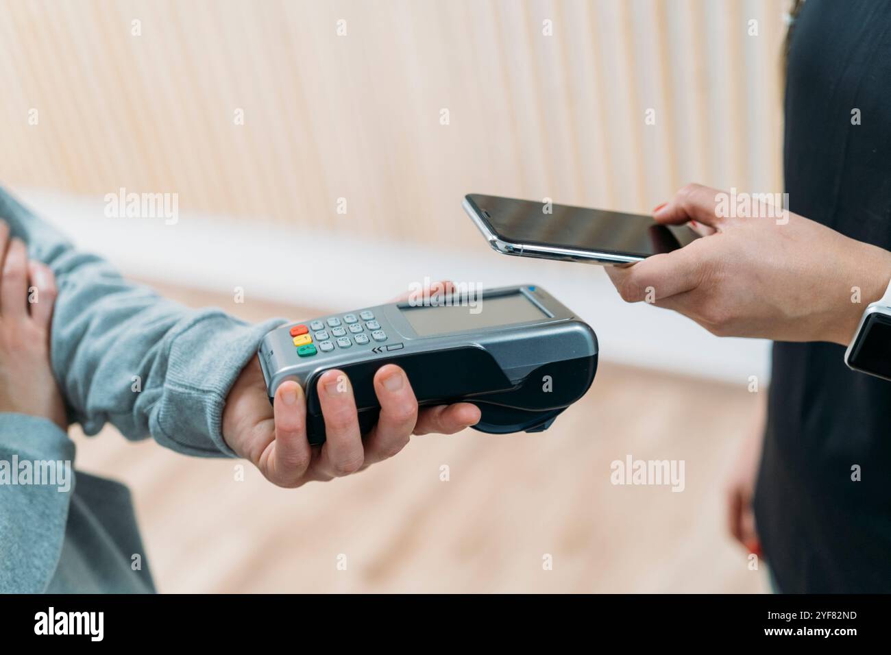 Customer using smartphone nfc technology to make a purchase at a store ...