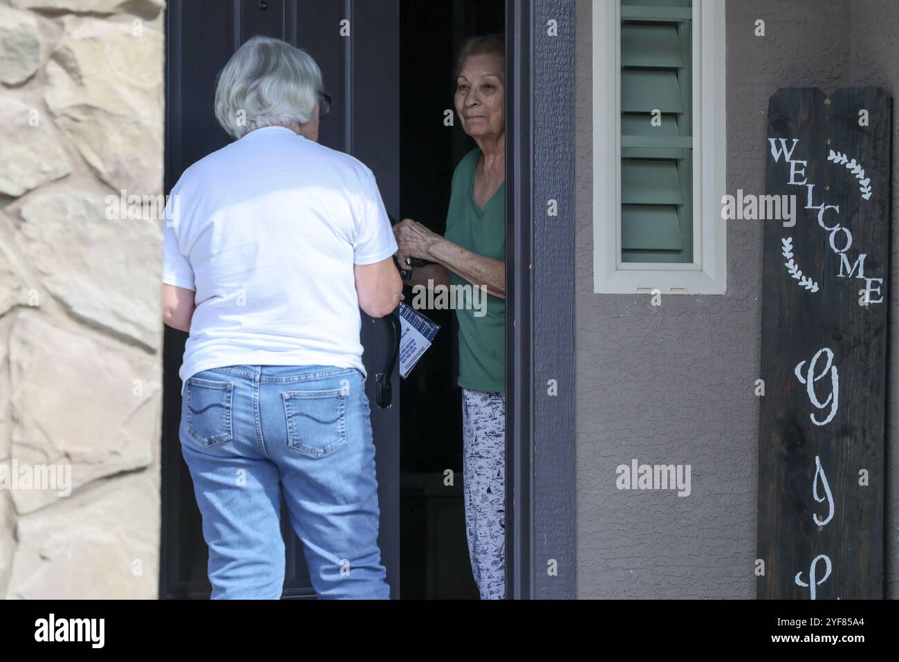 Mesa, USA. 03rd Nov, 2024. Volunteers Jessica and Kevin go door to door ...