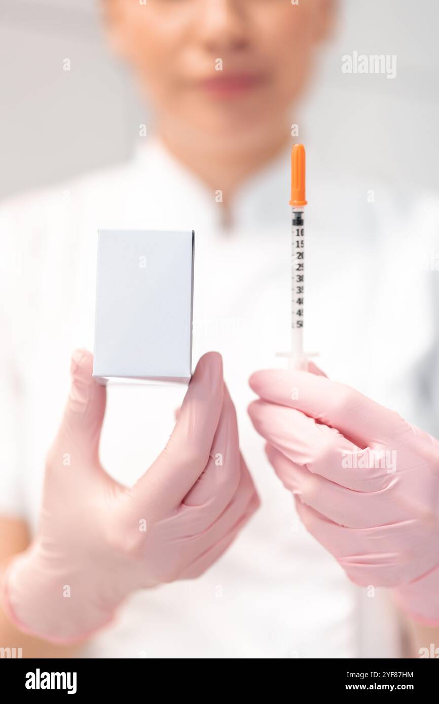 Anonymous female dermatologist holding injection syringe and medicine ...