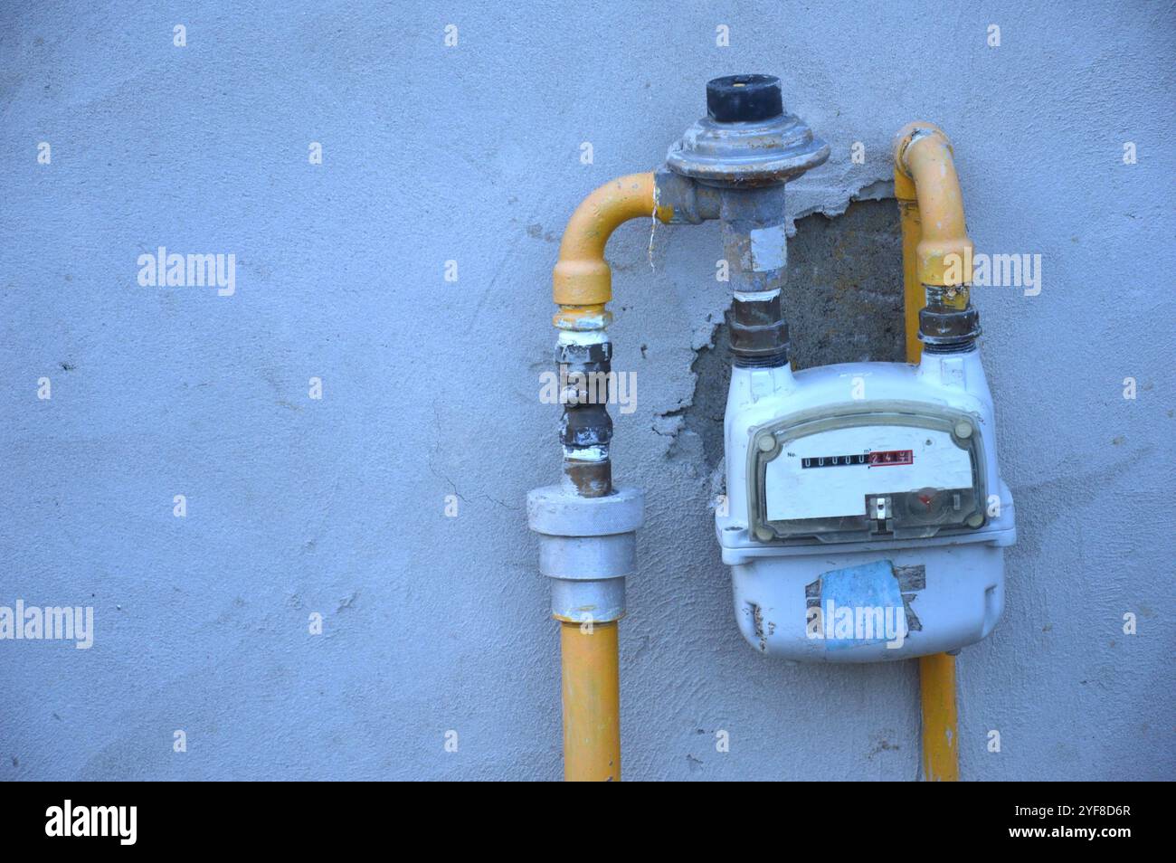 Natural gas meter with yellow pipe attached to the wall Stock Photo - Alamy