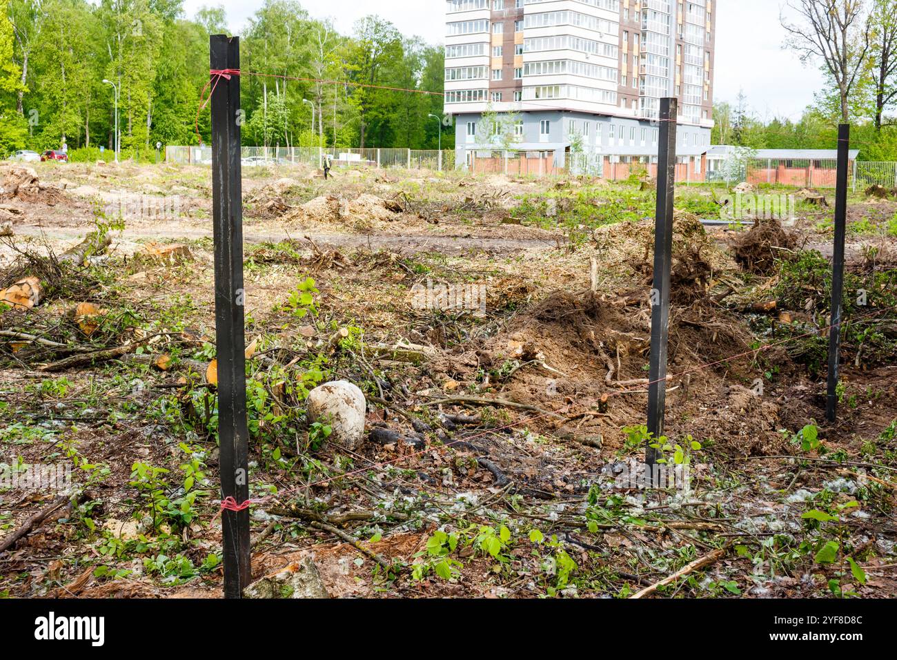Installing metal fence posts around a construction site Stock Photo - Alamy