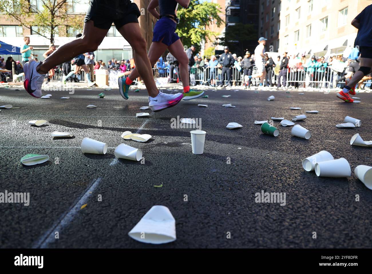 Runners step on used water cups discarded on the street during the 2024 ...