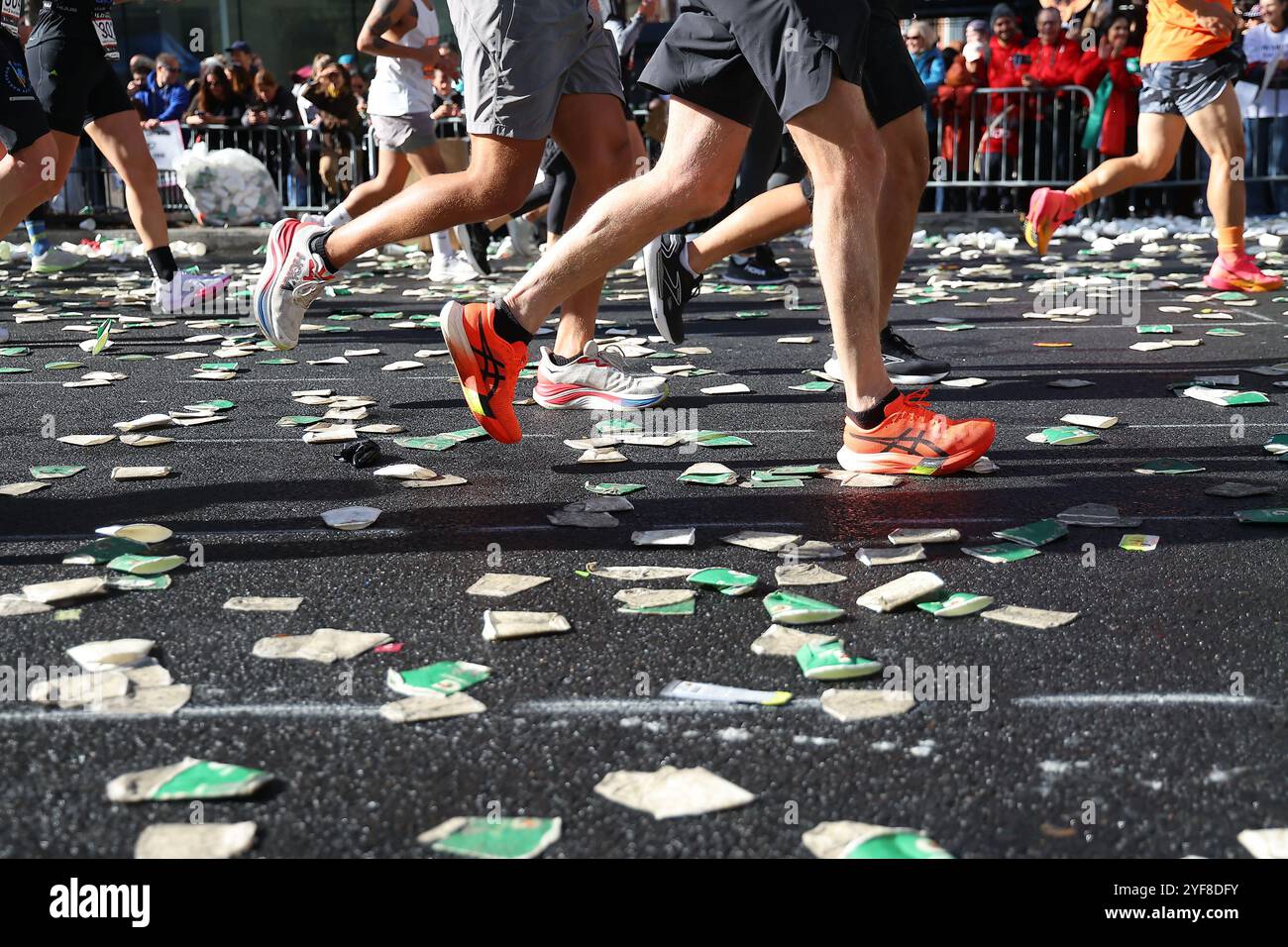 Runners step on used water cups discarded on the street during the 2024 ...