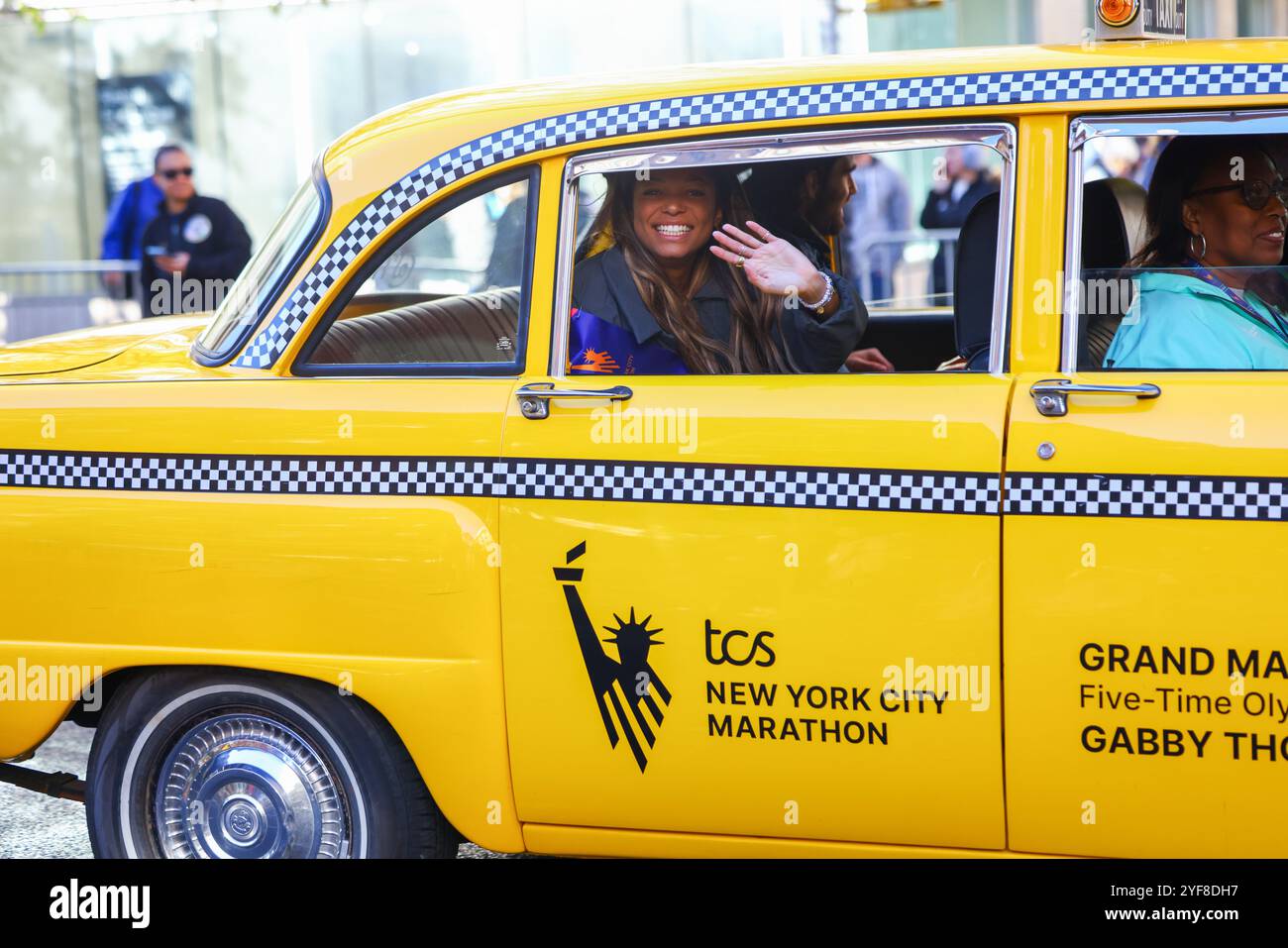 A checkered cab drives Grand Marshall Olympic champion Gabby Thomas up ...