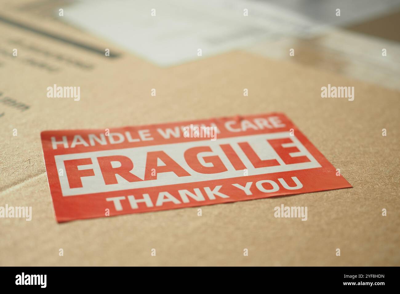 A cardboard box marked with a caution label for fragile goods handling during shipping Stock ...