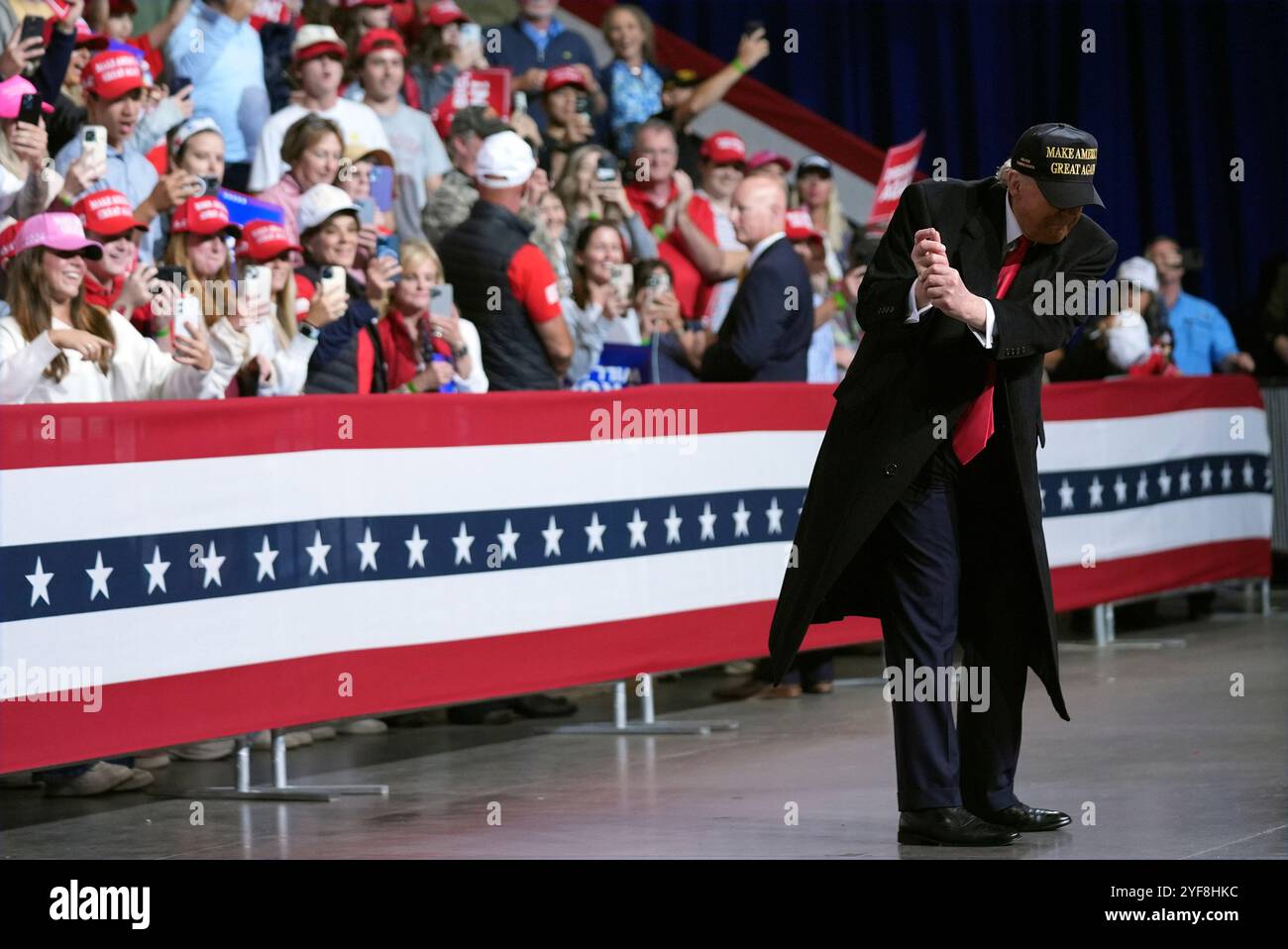 Republican presidential nominee former President Donald Trump mimics a ...