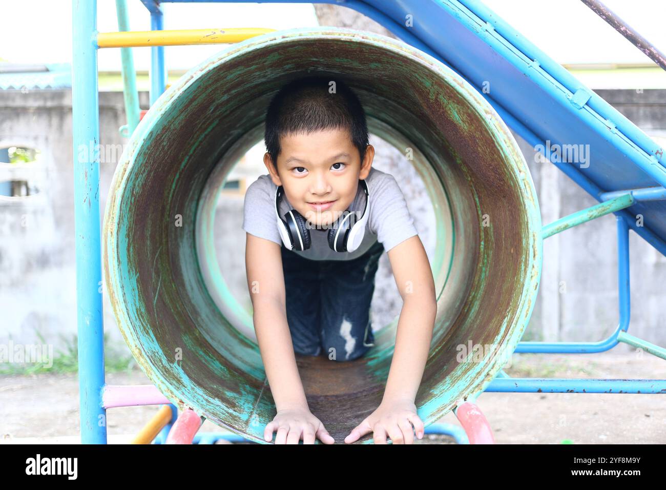 A cheerful child enjoys playing in a colorful playground, crawling ...