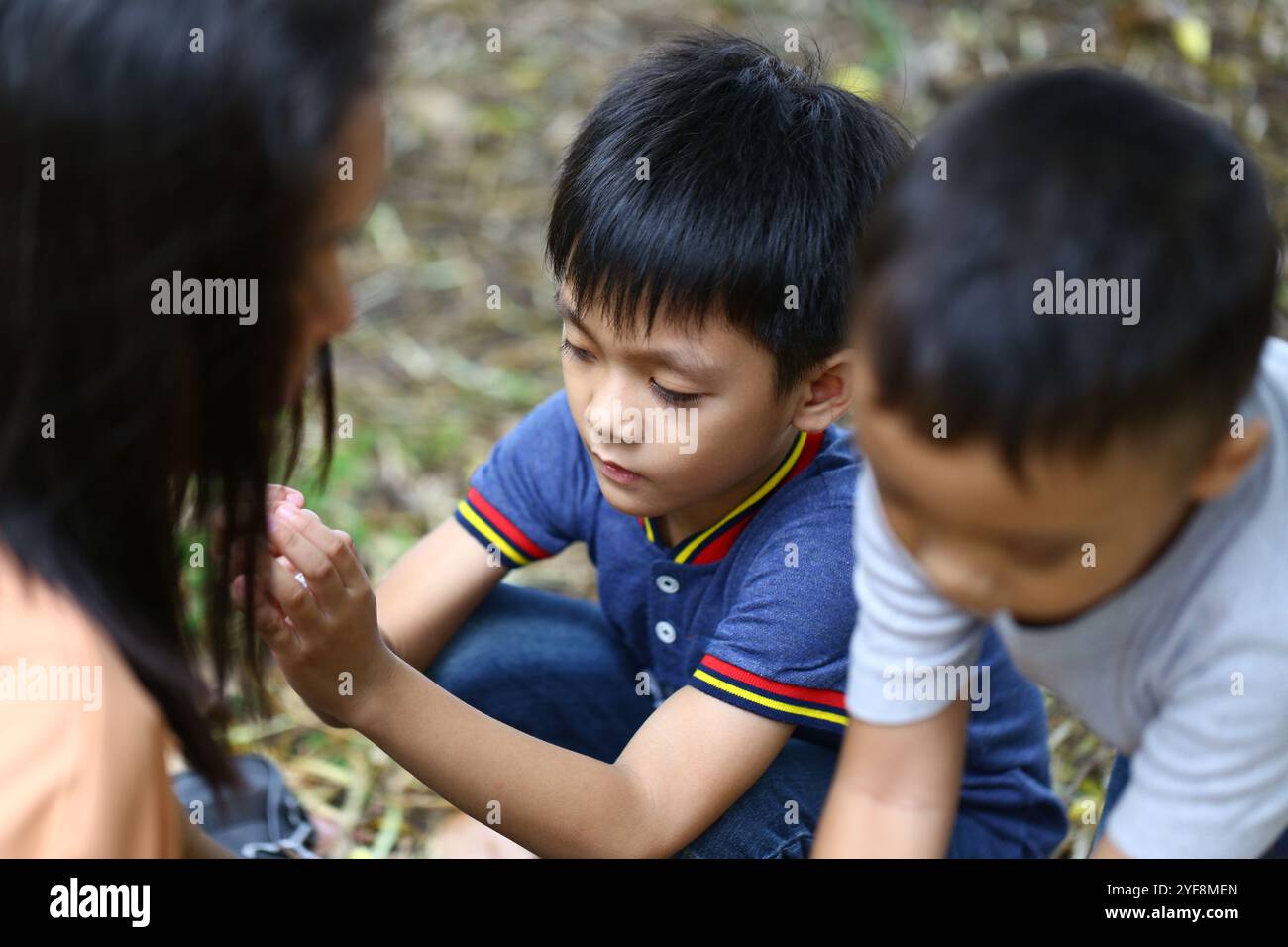 Two young children engage in playful interaction in a natural outdoor ...