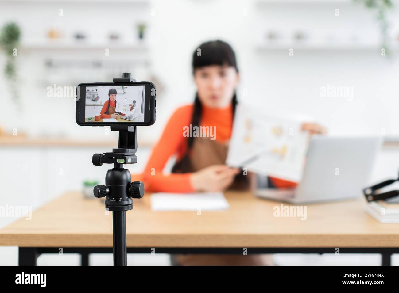 Caucasian female influencer recording video tutorial with smartphone ...