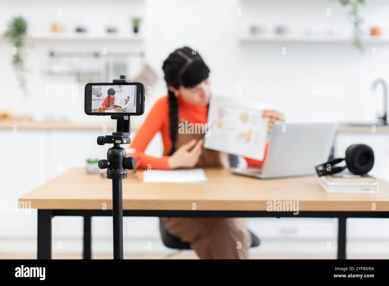 Caucasian woman influencer filming educational content with smartphone ...