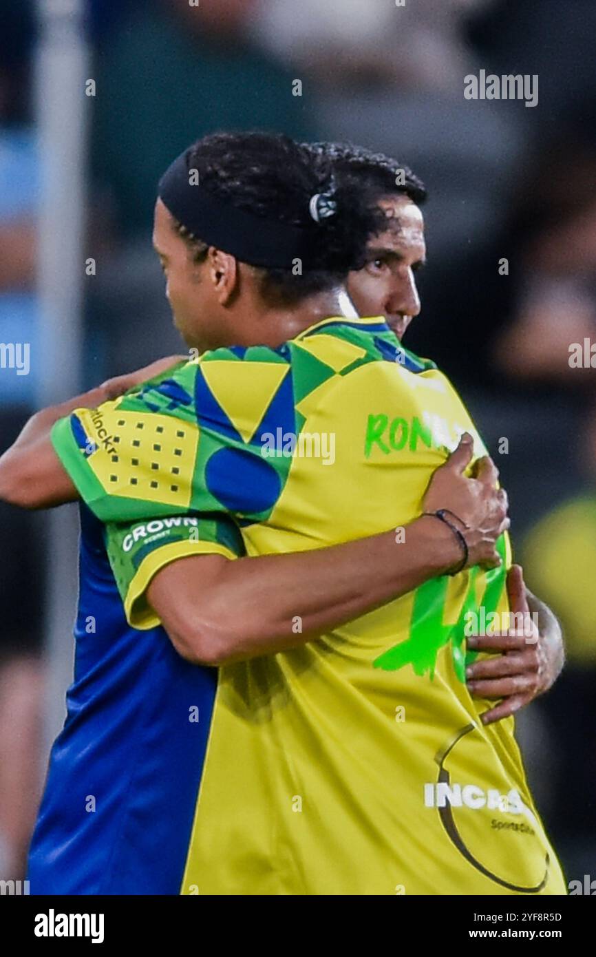 Ronaldinho of Ronaldinho's XI and Tim Cahill of Cahill's XI hug as ...