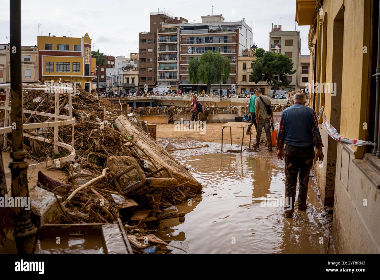 Locals and volunteers are seen manually cleaning up the streets filled ...