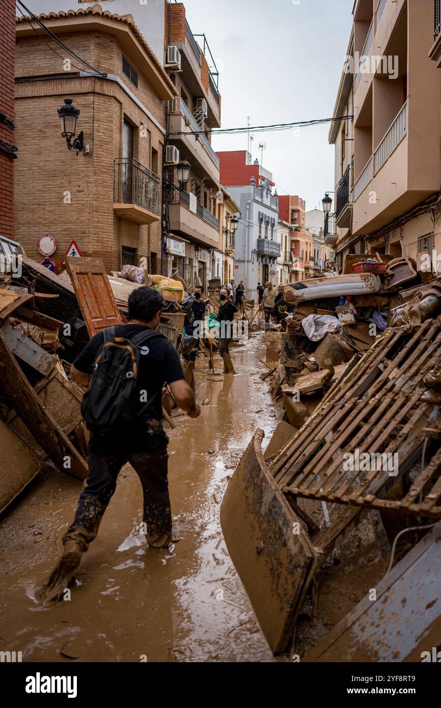 Locals and volunteers are seen manually cleaning up the streets filled ...