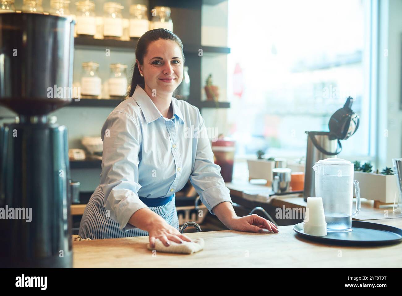 Woman portrait, counter and cleaning at cafe, service and wipe dirt ...