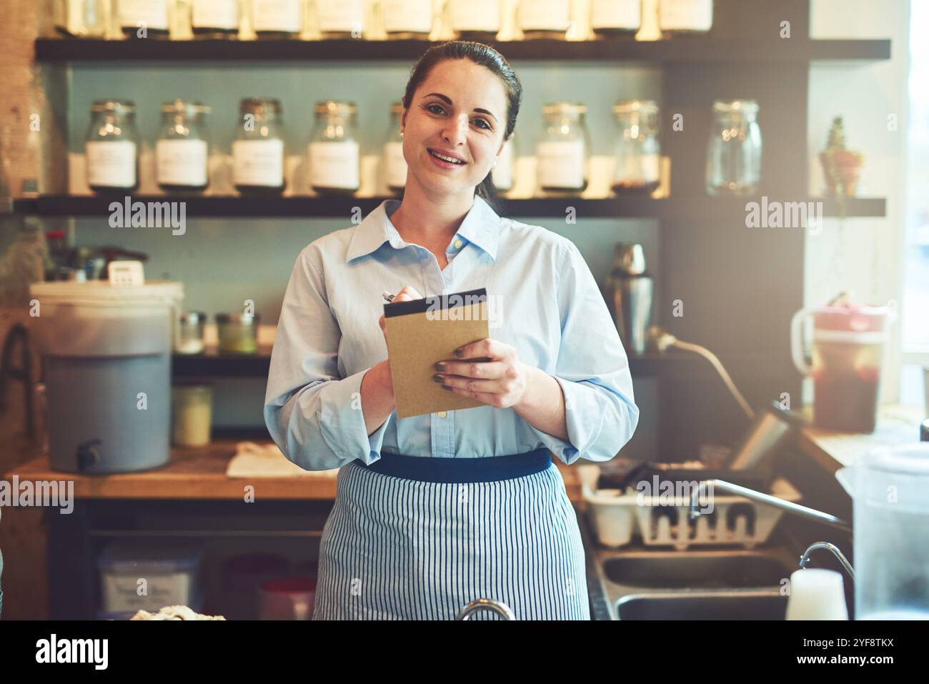 Barista, happy and portrait with notebook in restaurant with confidence ...