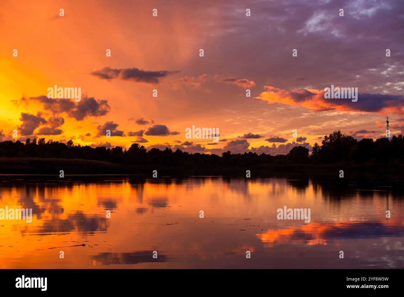 Amazing sunrise in rural scene. Symmetry of the sky in a lake at sunset ...
