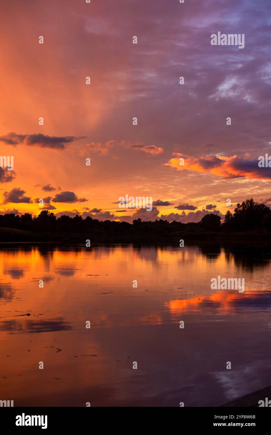 Amazing sunrise in rural scene. Symmetry of the sky in a lake at sunset ...