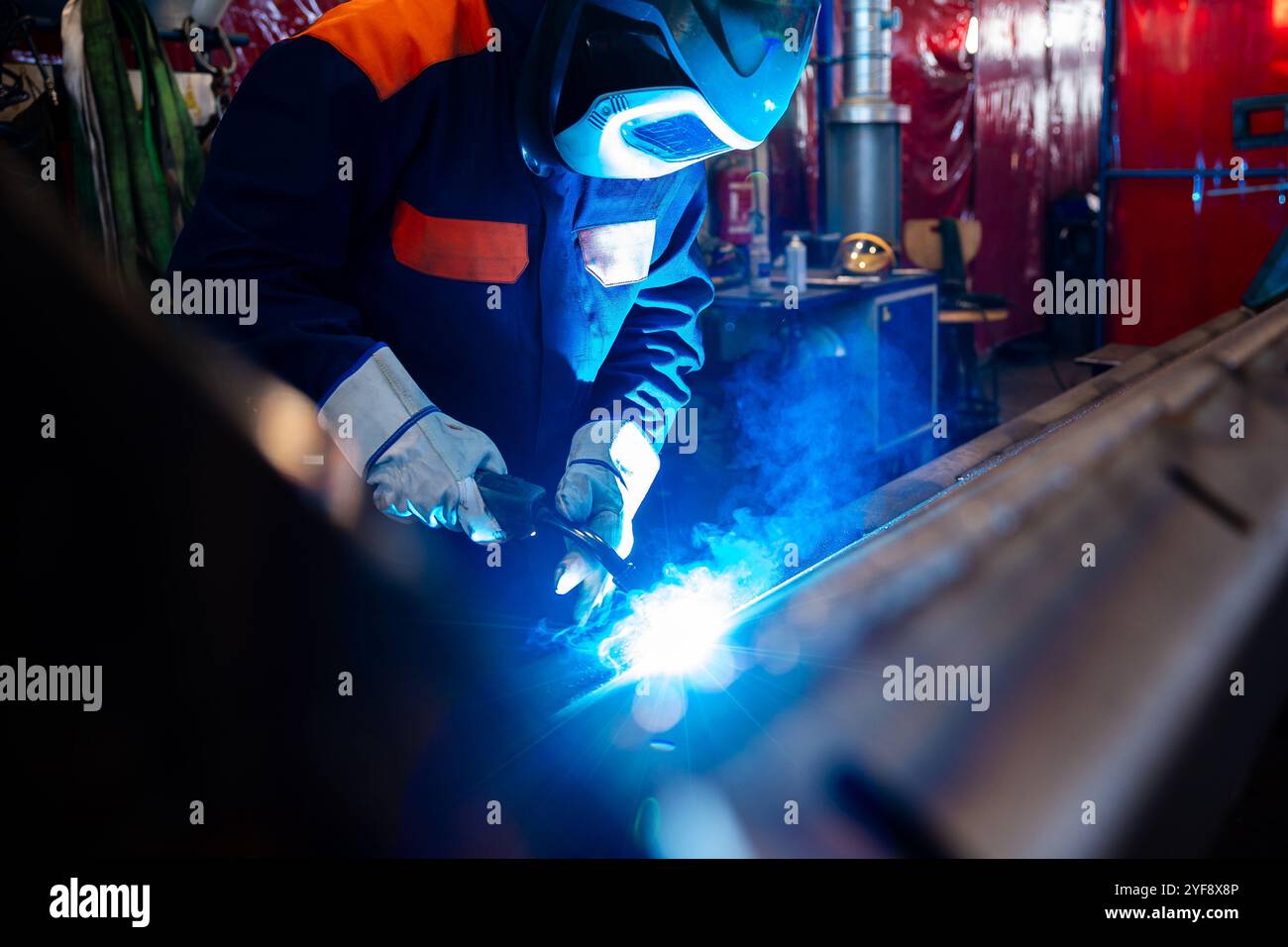Metal welding steel works using electric arc welding machine to weld steel at factory. Metalwork ...
