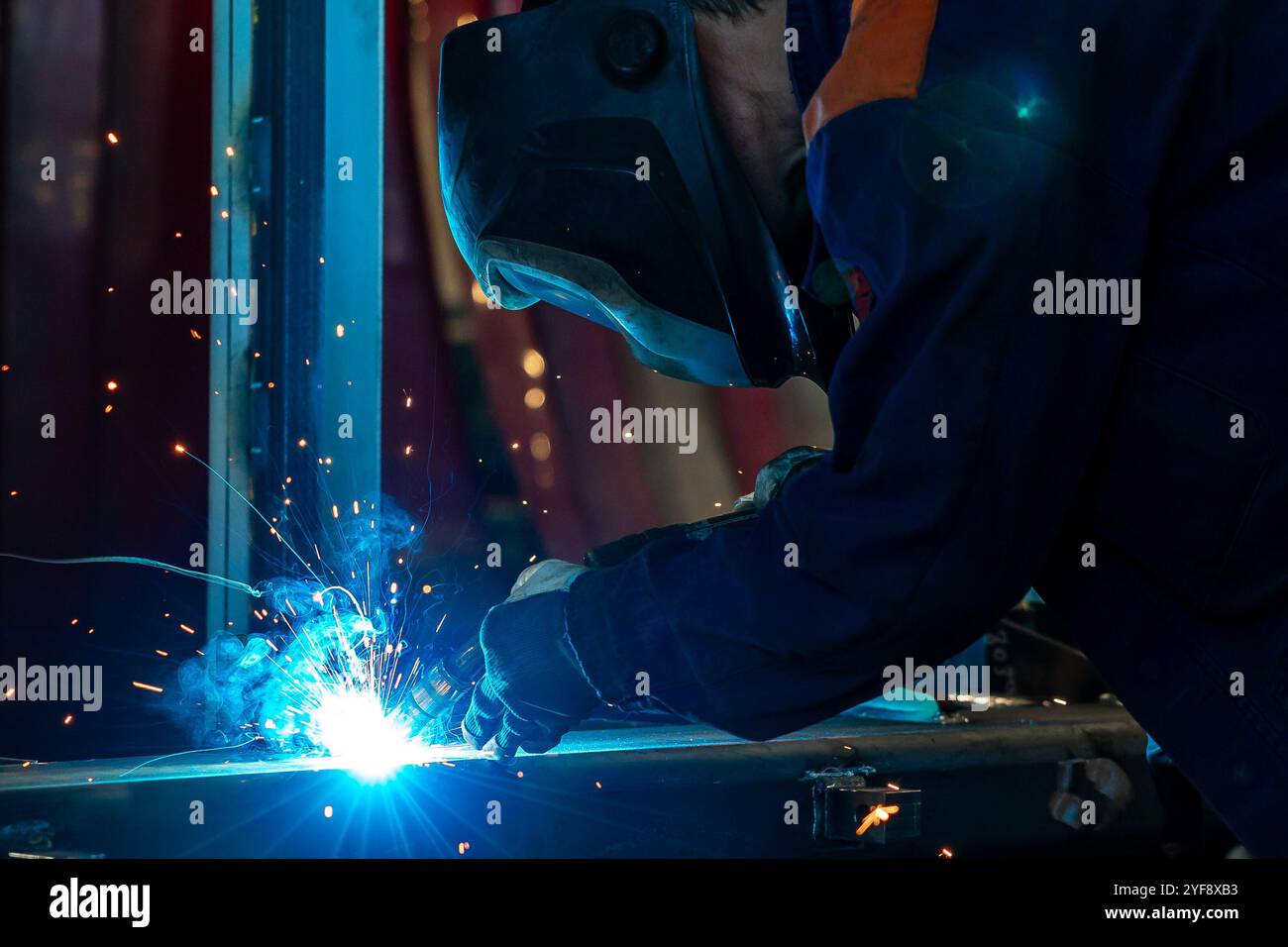 welder and welding sparks, construction and metal work industrial ...
