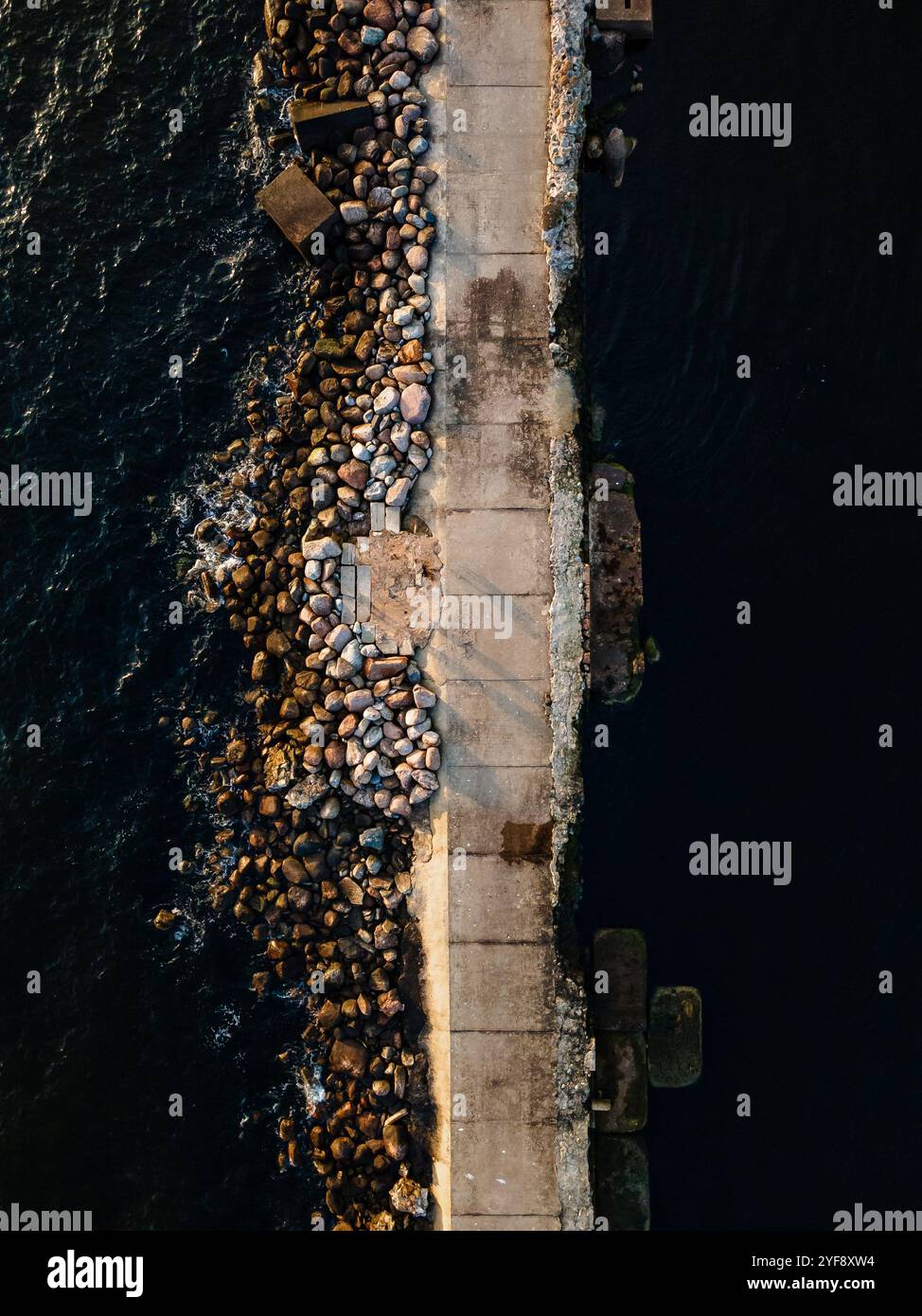 Pathway leading to a lighthouse. Water waves crashing over the rocks ...