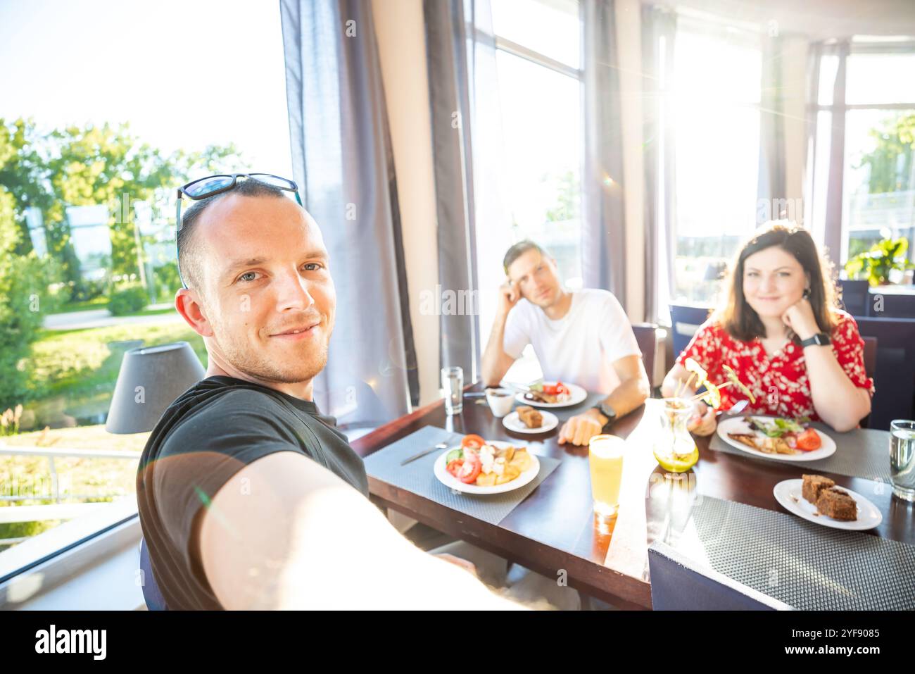 Sunlit Casual Dining Scene with Friends Enjoying a Meal Together in a ...