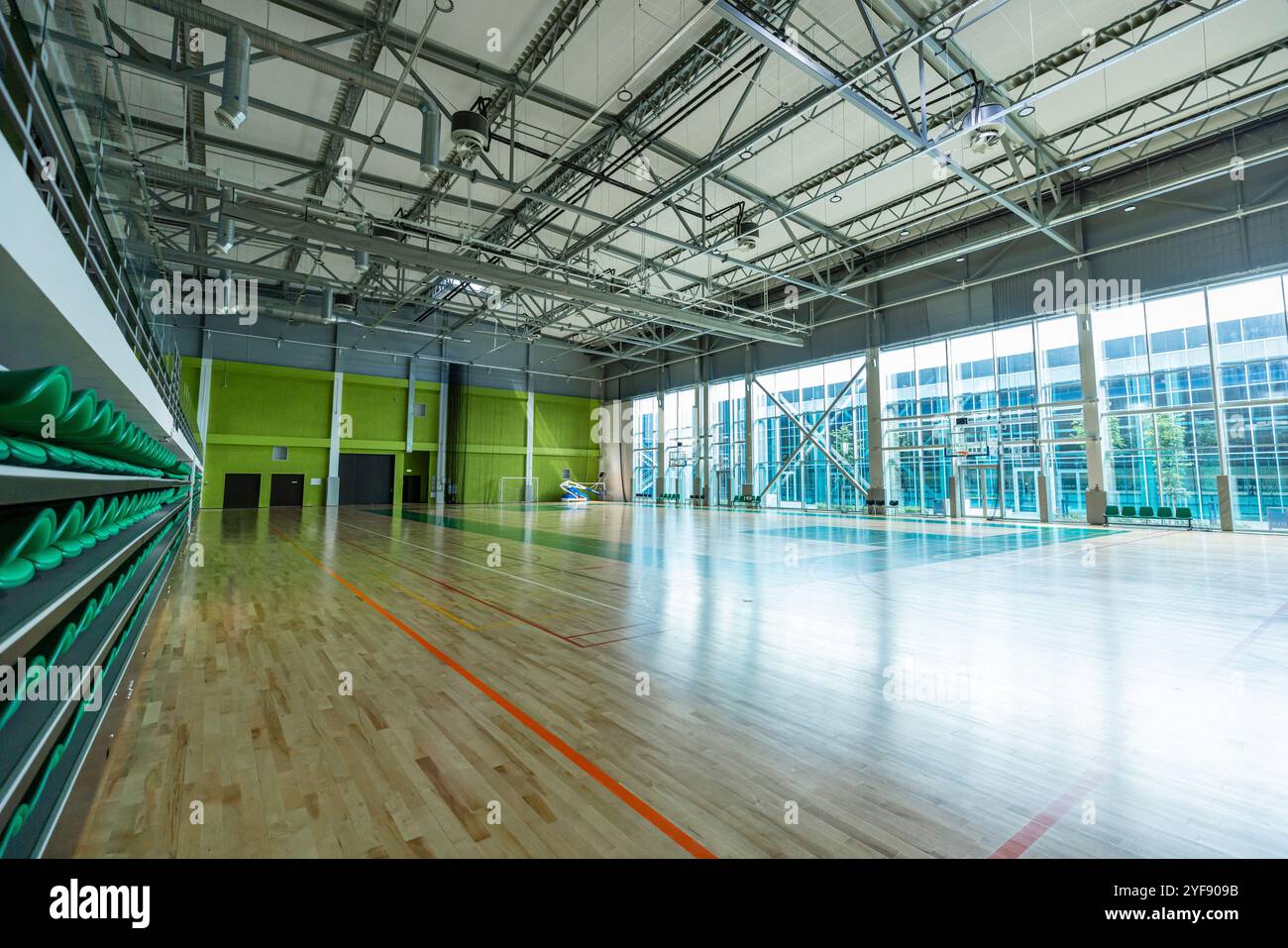 Spacious Modern Indoor Sports Arena with Vibrant Green Spectator Seats ...