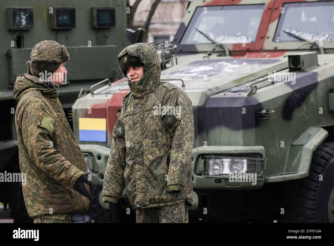 Russian servicemen talk against the backdrop of captured military ...