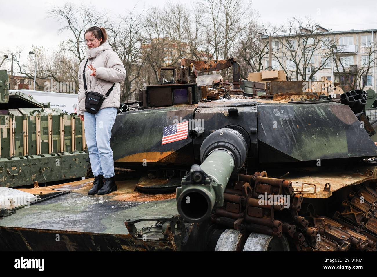 A girl poses on an American M1 Abrams tank captured by Russian troops ...