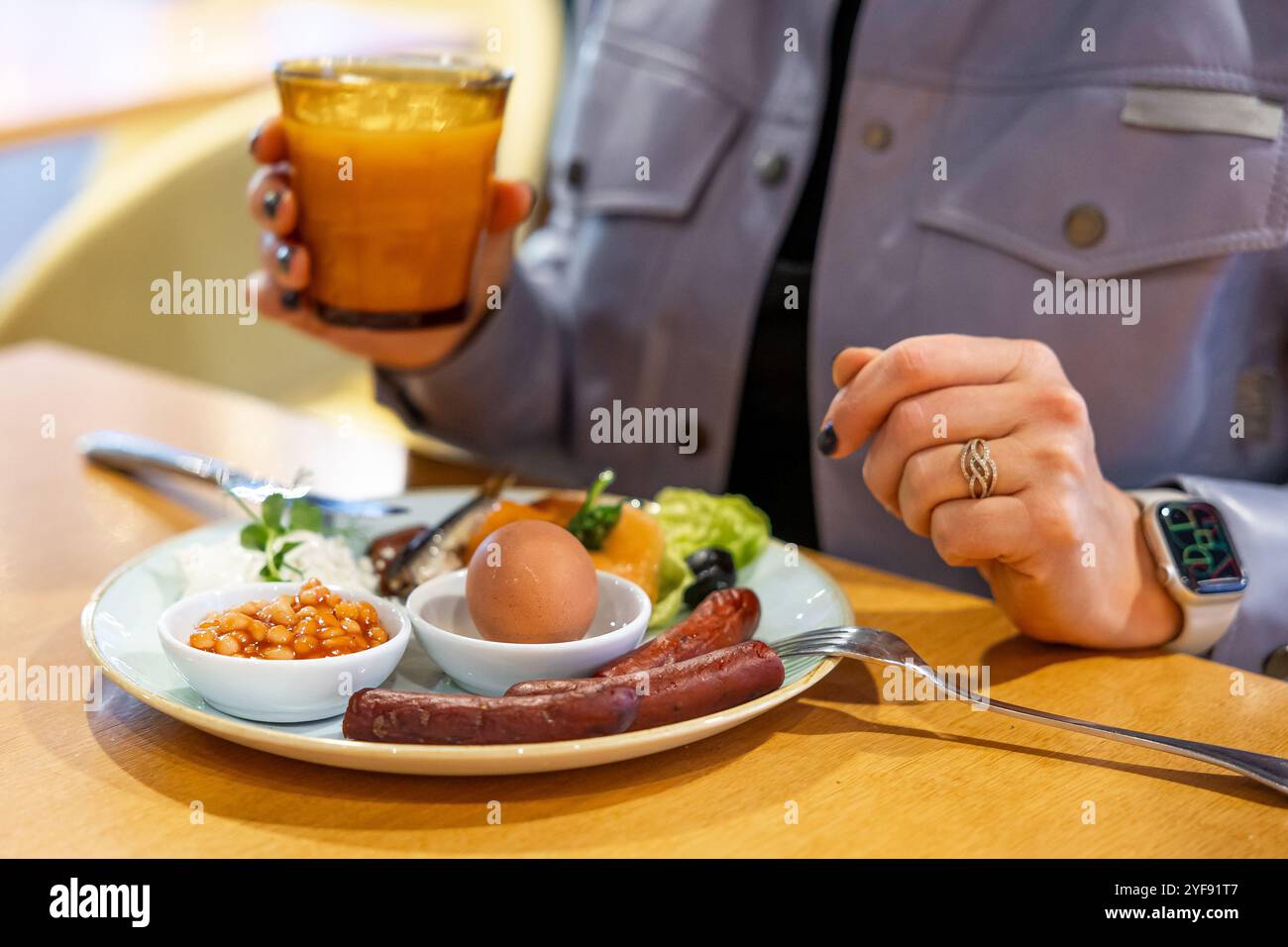Woman eating Full English Breakfast with Beans, Sausages, Boiled Eggs ...