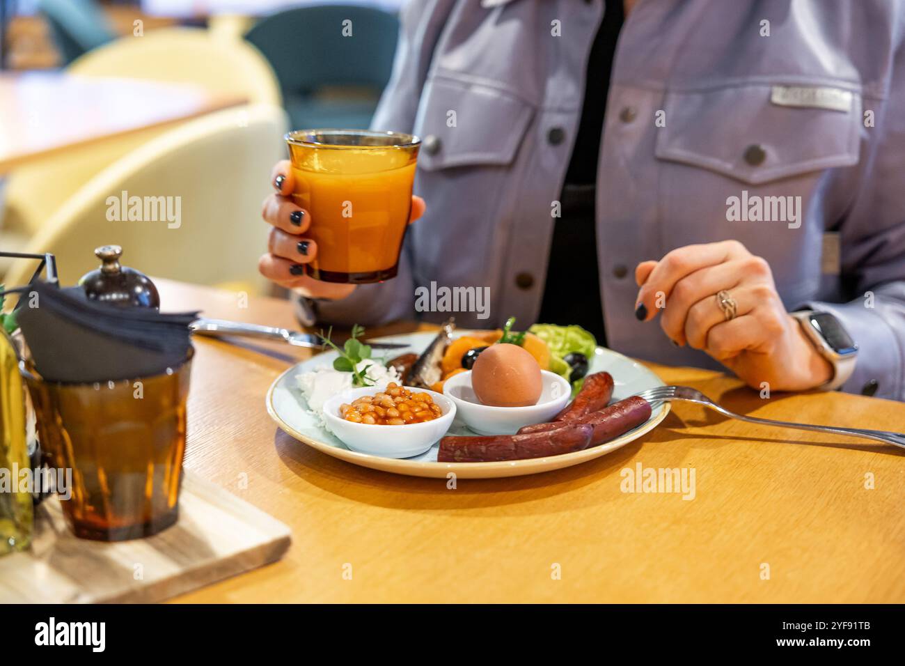 Woman eating Full English Breakfast with Beans, Sausages, Boiled Eggs ...