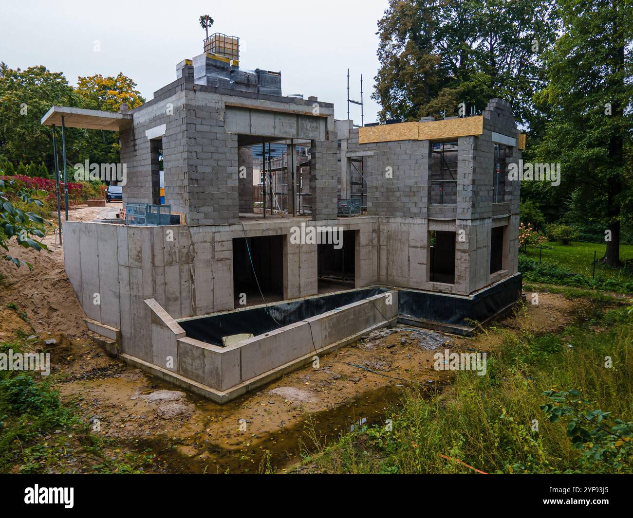 Progress on a suburban home construction site with exposed cinder block ...