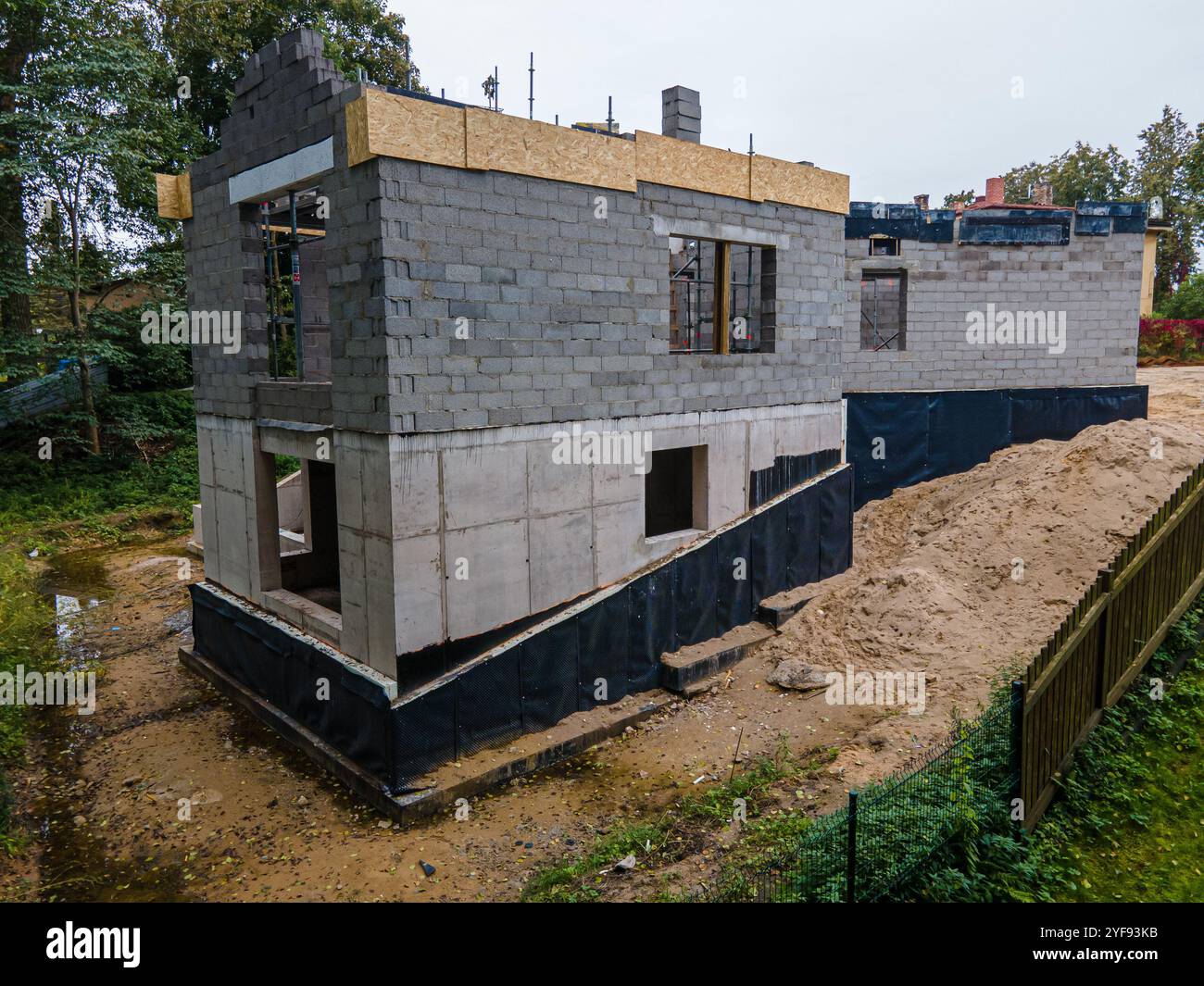 Progress on a suburban home construction site with exposed cinder block ...