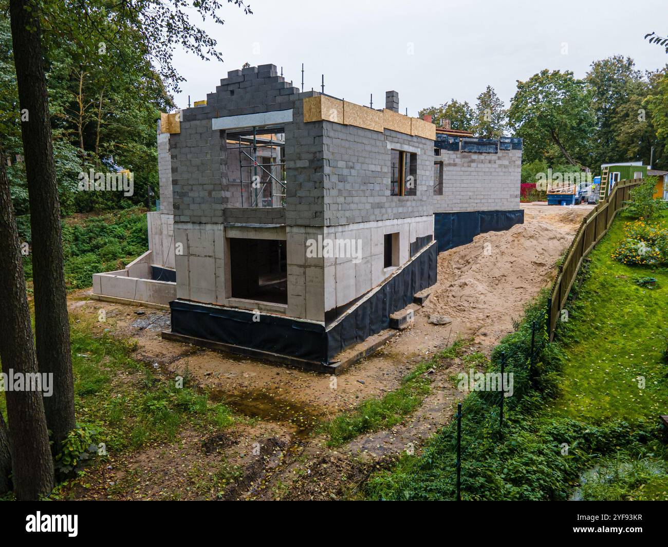Progress on a suburban home construction site with exposed cinder block ...