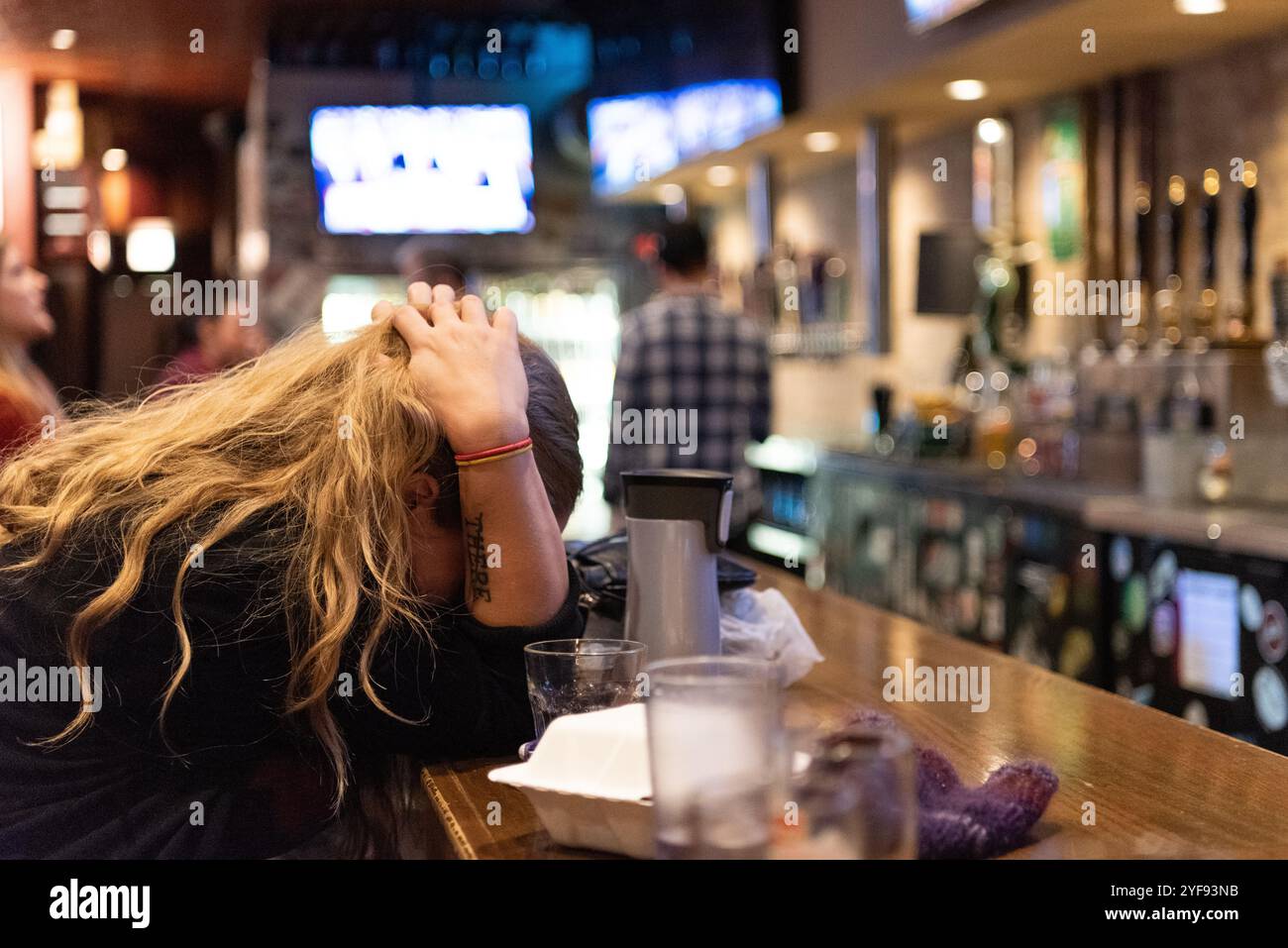 A patron at a bar in Chicago, Illinois reacts to the announcement of ...